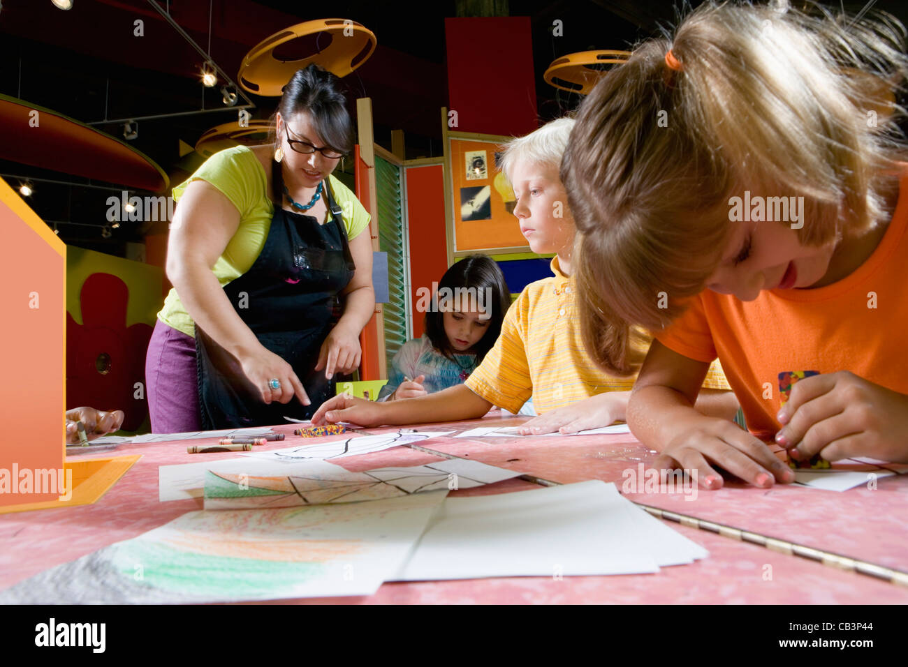 An art teacher teaching her young students in art class Stock Photo - Alamy