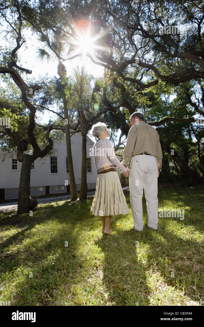 Rear view of mature couple standing under oak trees Stock Photo - Alamy