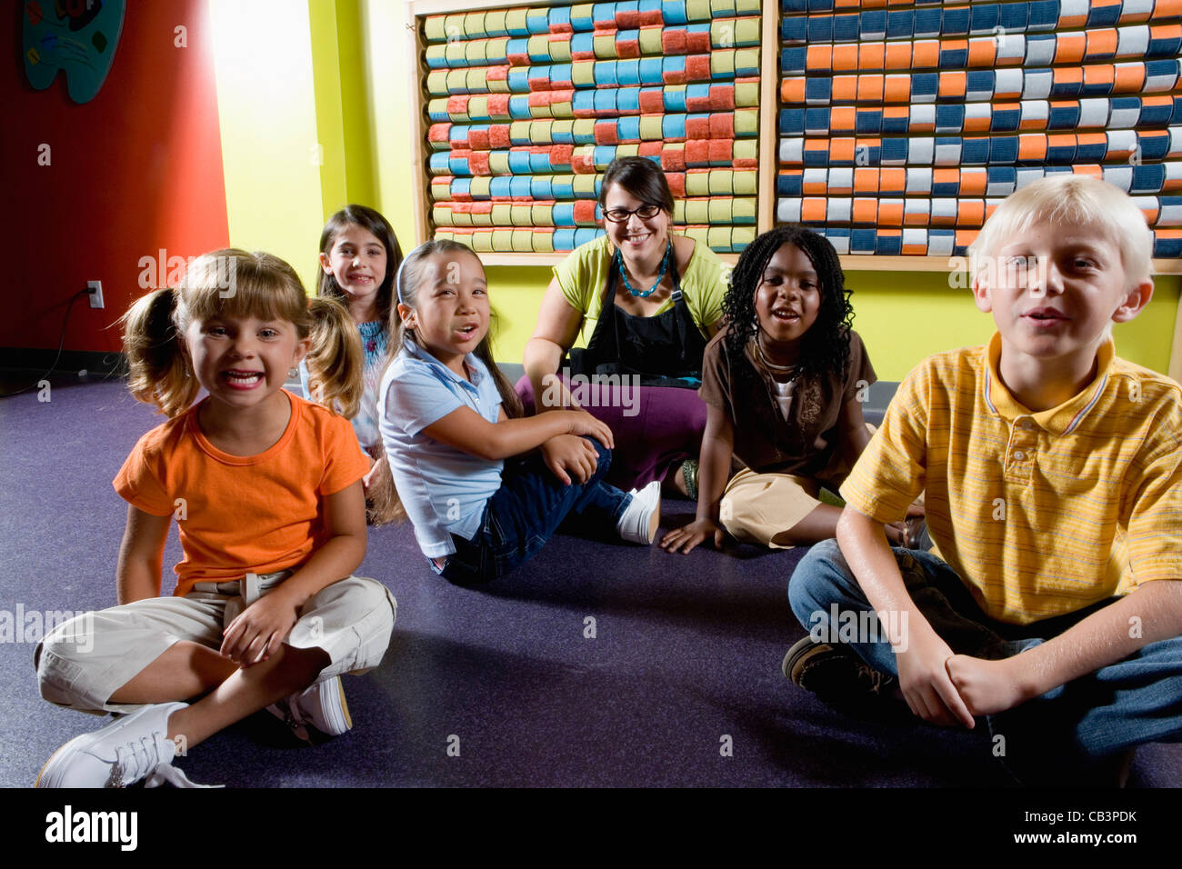 Teacher sitting with young children Stock Photo - Alamy