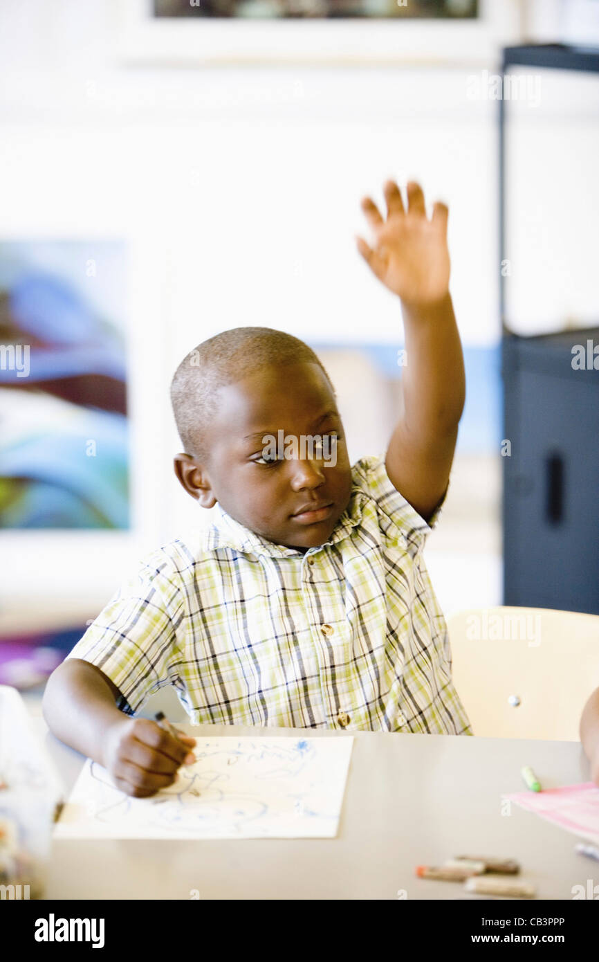 Close up of little boy raising his hand Stock Photo - Alamy