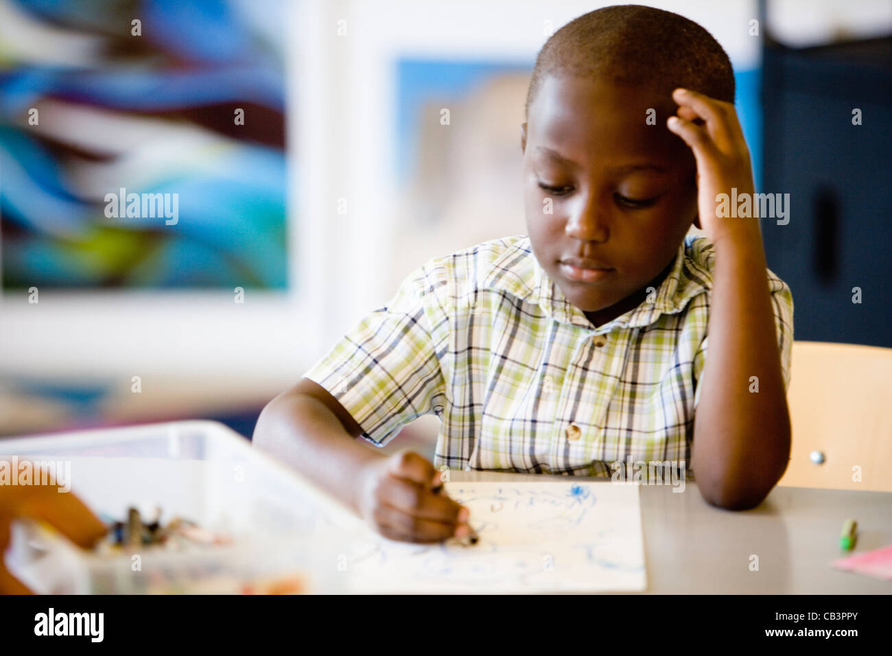 Boy drawing with crayon in art class Stock Photo - Alamy