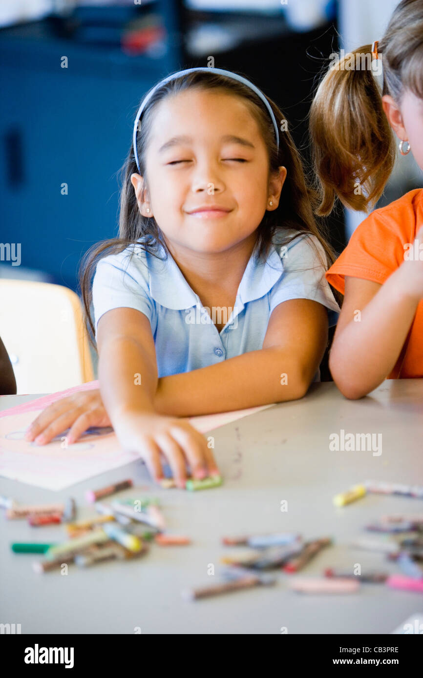 Little girl picking crayon with eyes closed Stock Photo - Alamy