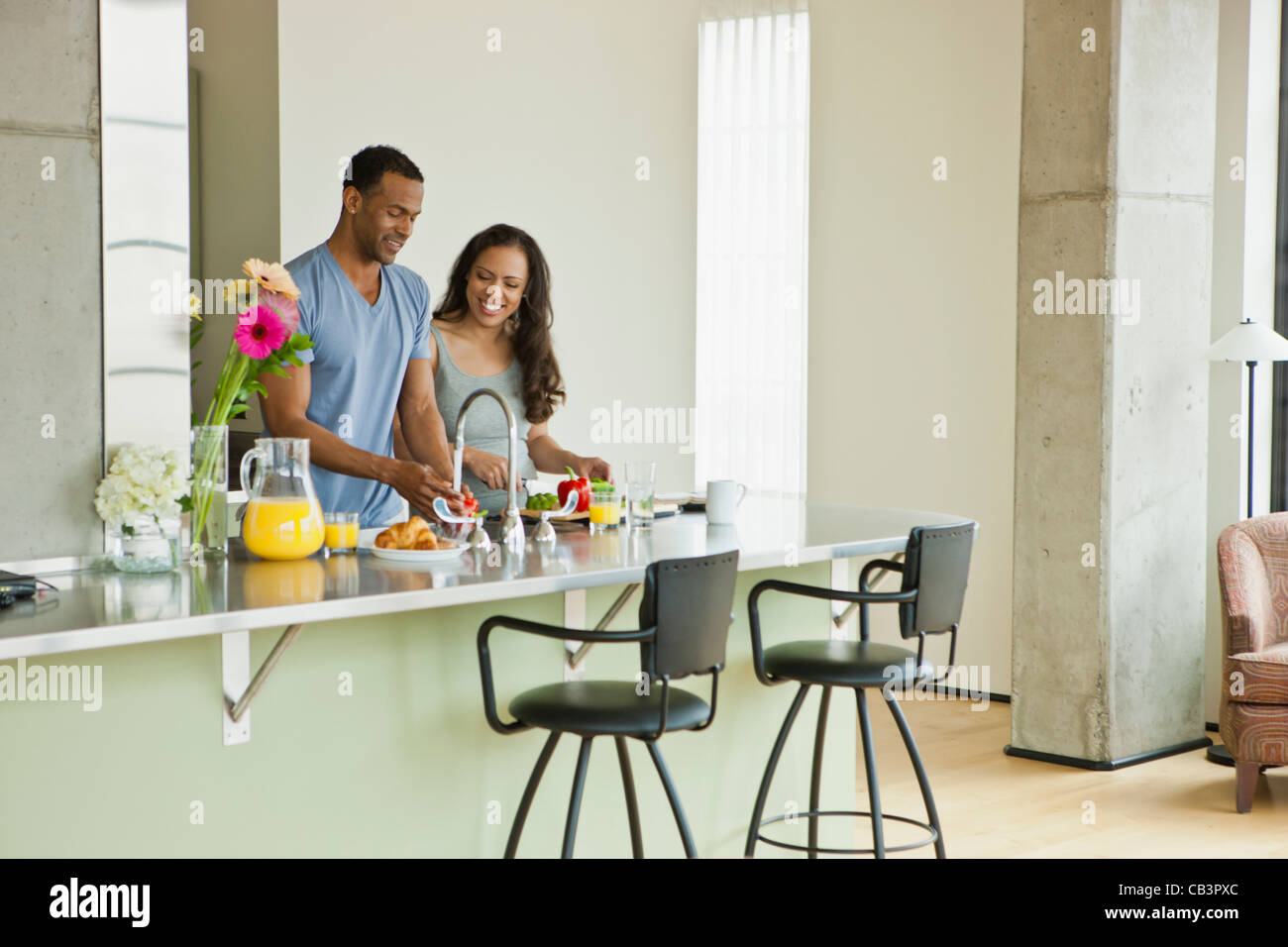 Couple making breakfast in loft apartment Stock Photo - Alamy
