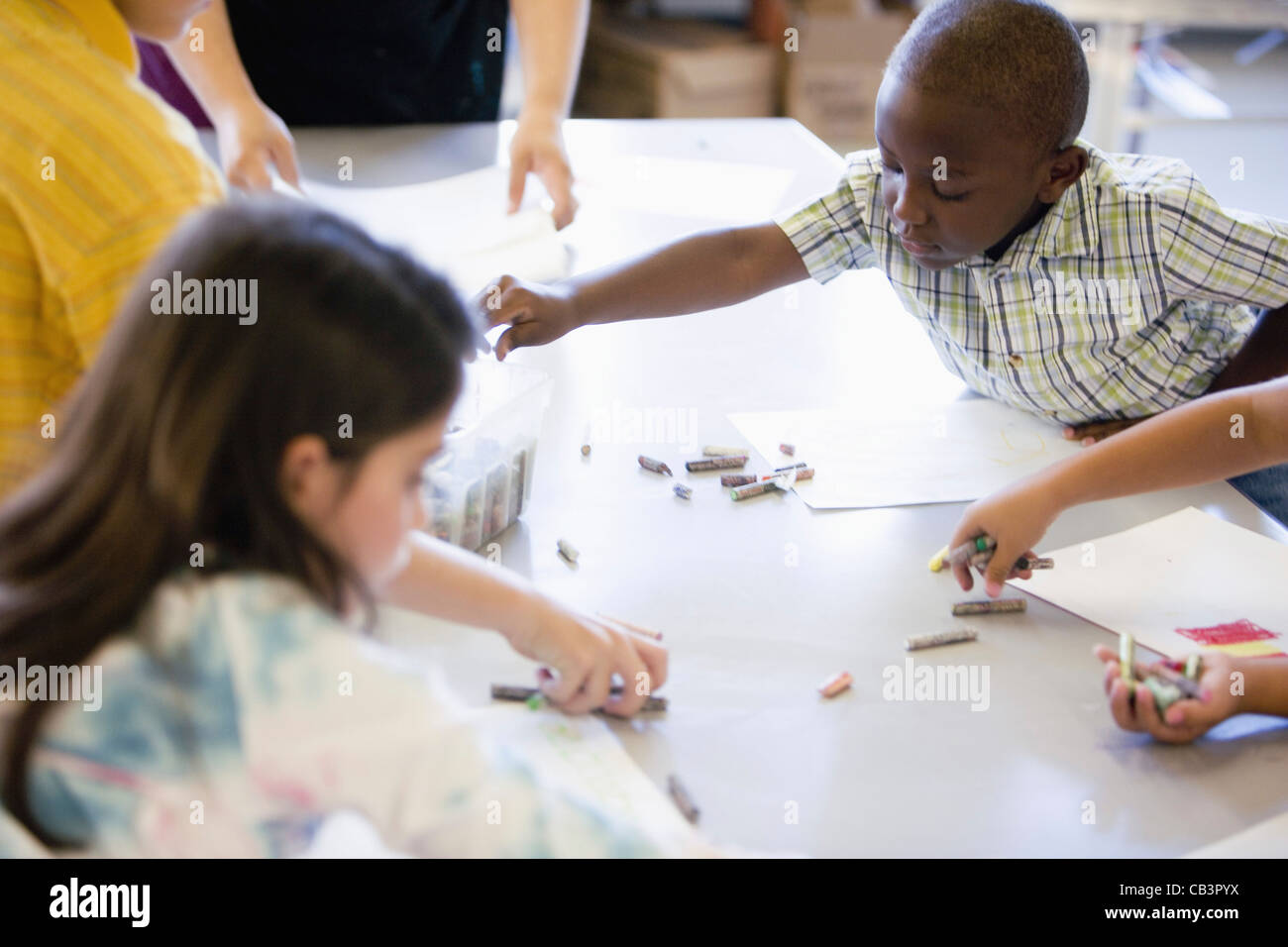Kids drawing with crayons at a table hi-res stock photography and ...