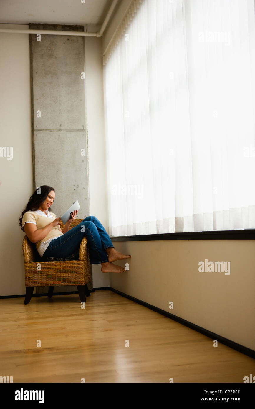 Woman reading book in loft apartment Stock Photo - Alamy