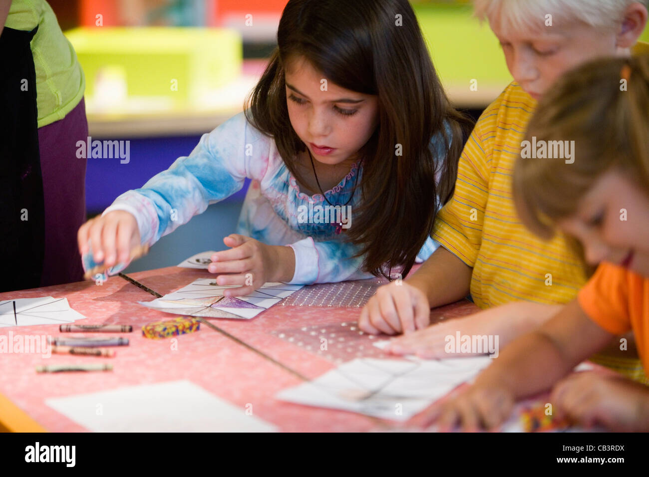 Three children coloring with crayons Stock Photo - Alamy
