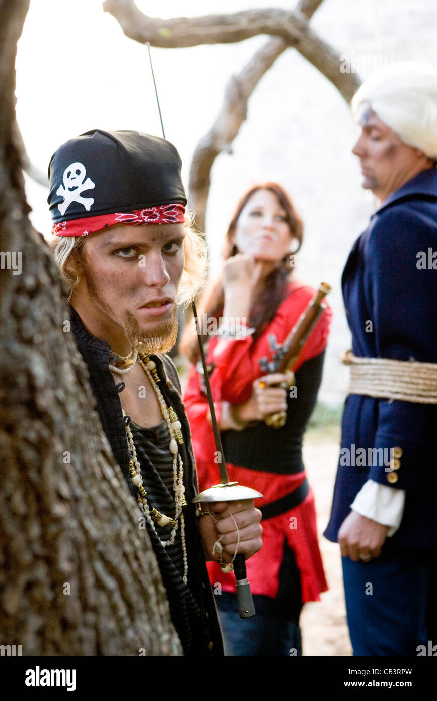 Portrait of pirates holding and threatening a captive navy officer with ...