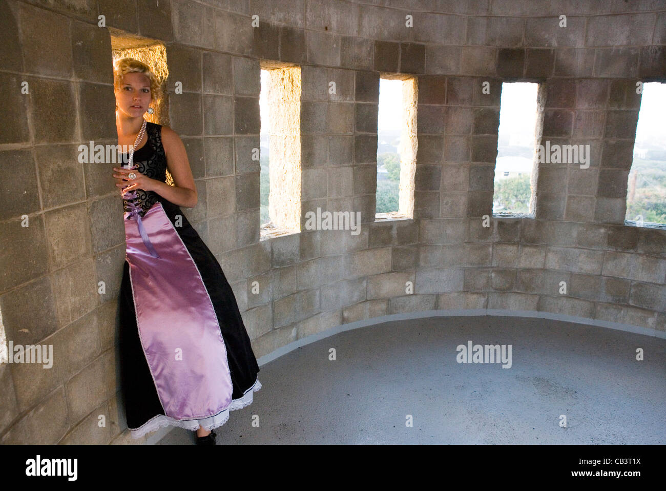 Portrait of a young princess sitting against a window in a castle ...