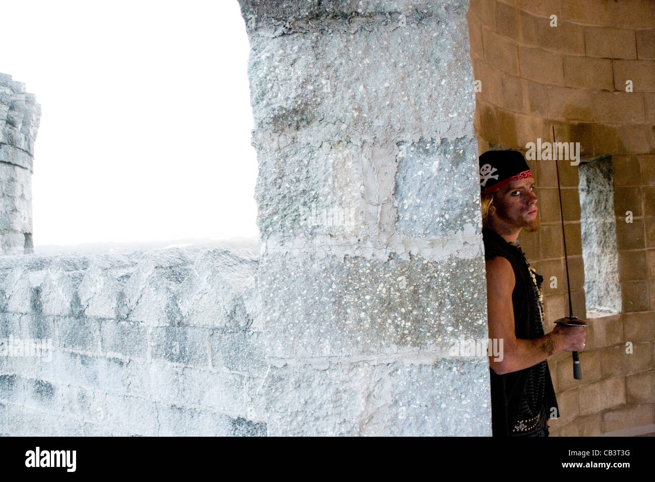 Portrait of a pirate armed with a sword leaning and hiding against a ...