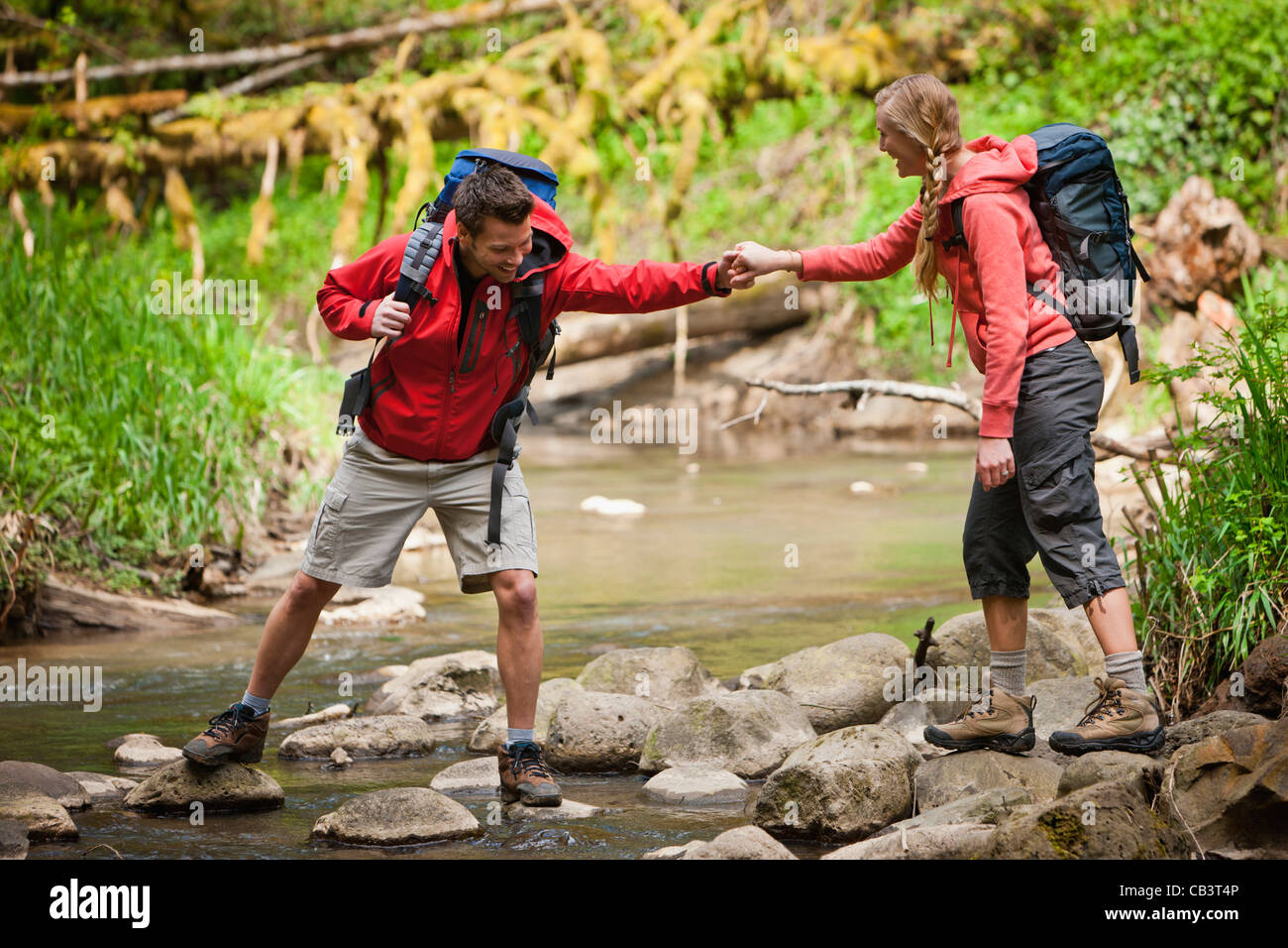 Portland, Oregon, USA, Man helping woman across creek Stock Photo - Alamy