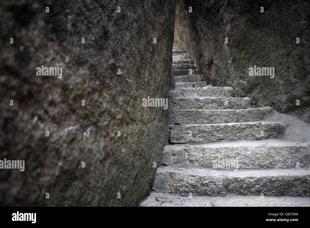 stone staircase leading up to vanishing point between stone walls ...