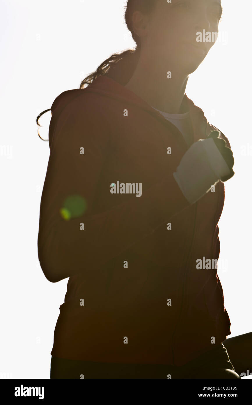 Woman jogging, backlit by sun Stock Photo - Alamy