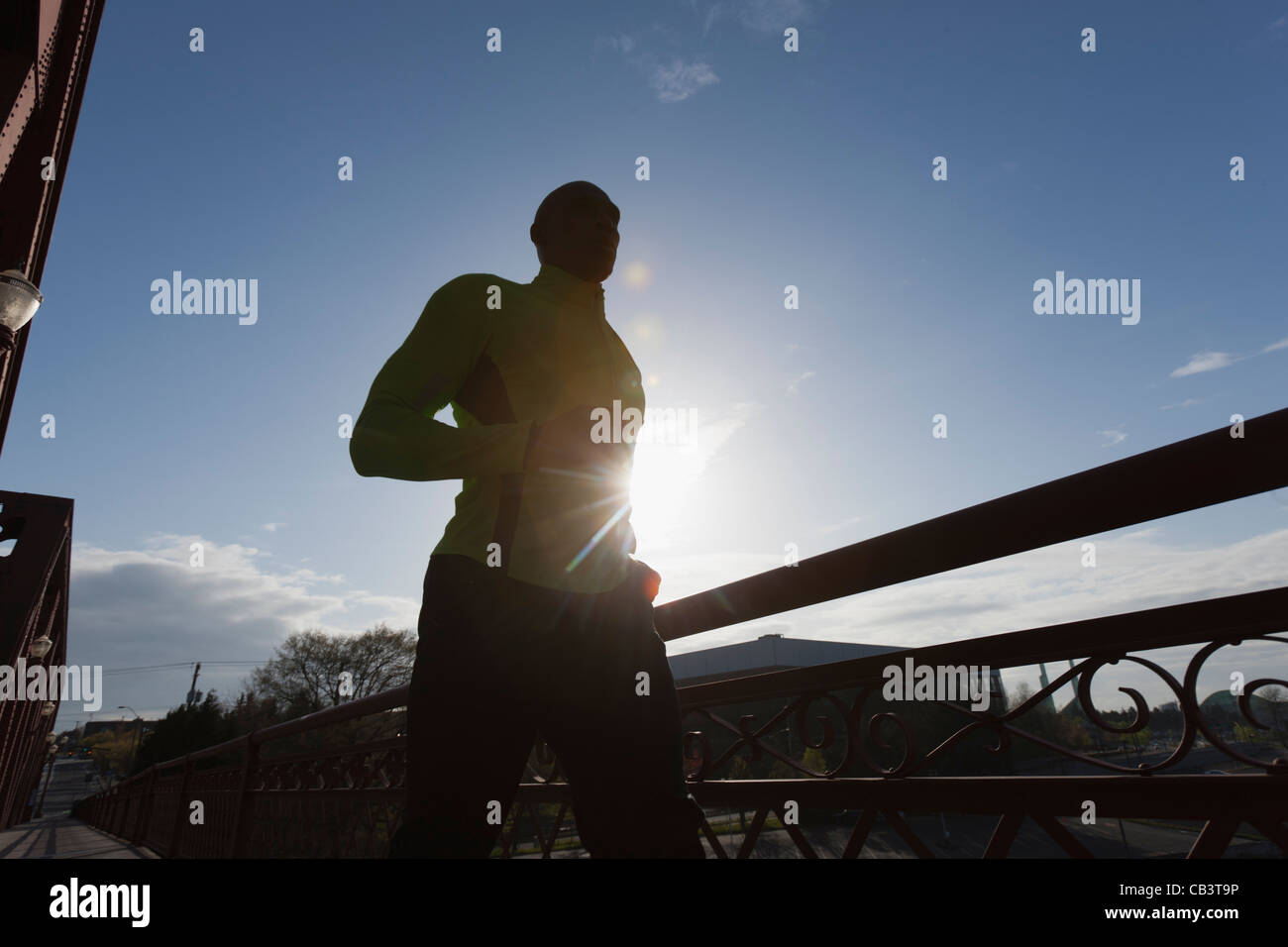 Man jogging, backlit by sun Stock Photo - Alamy