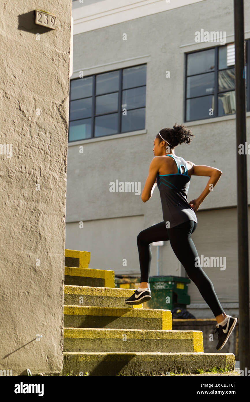 Woman jogging up steps Stock Photo - Alamy