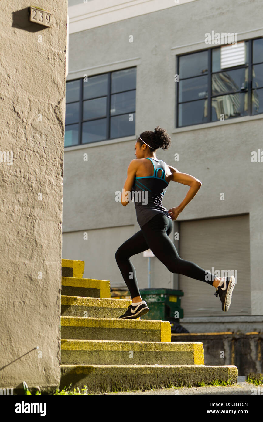 Woman jogging up steps Stock Photo - Alamy