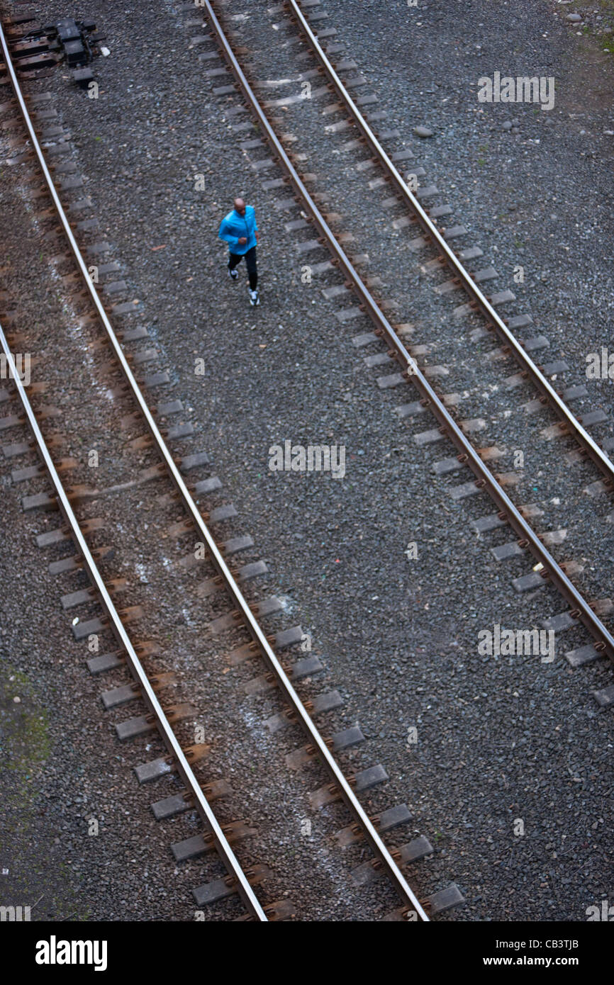Man running across railroad tracks Stock Photo - Alamy