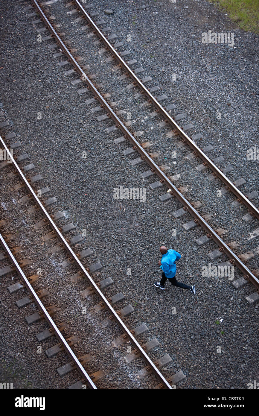 Man running across railroad tracks Stock Photo - Alamy