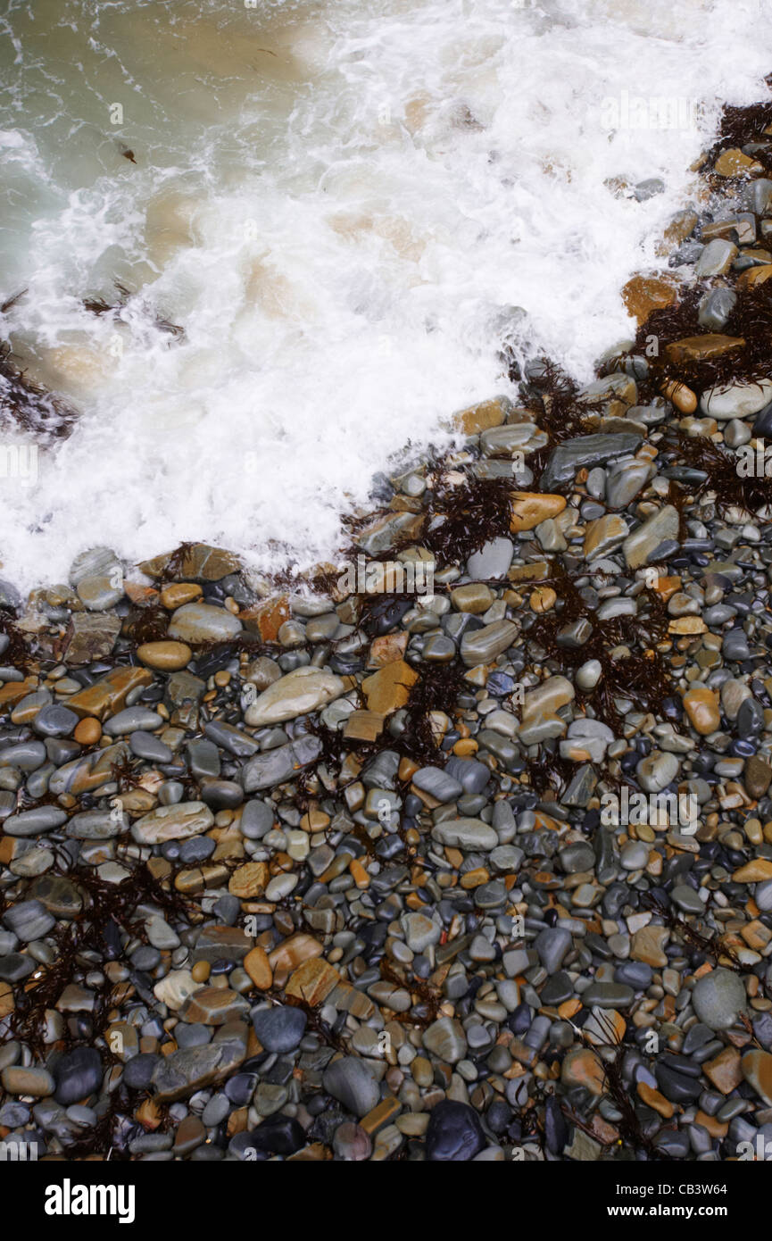 Wave crashing over pebbles Stock Photo - Alamy