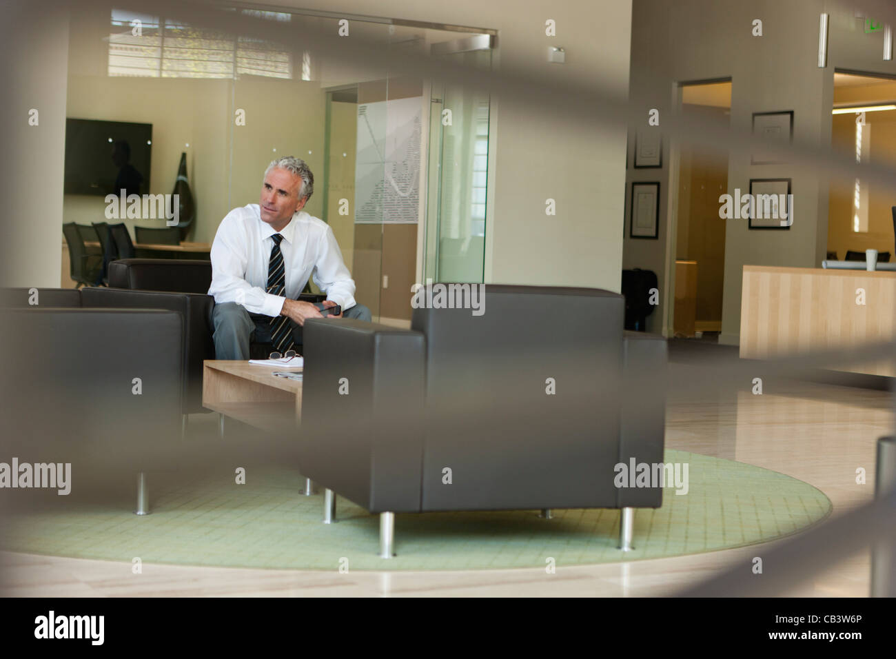 Businessman waiting in office lobby Stock Photo - Alamy