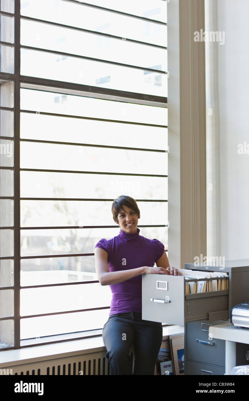 Portrait of businesswoman at filing cabinet in office Stock Photo - Alamy
