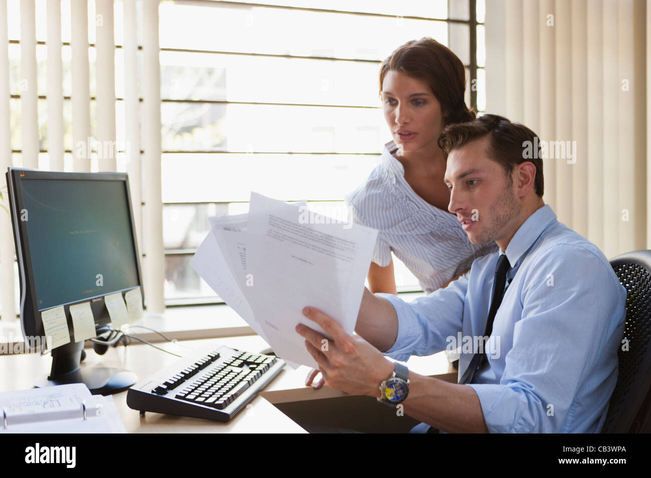 Employees collaborating at desk Stock Photo - Alamy