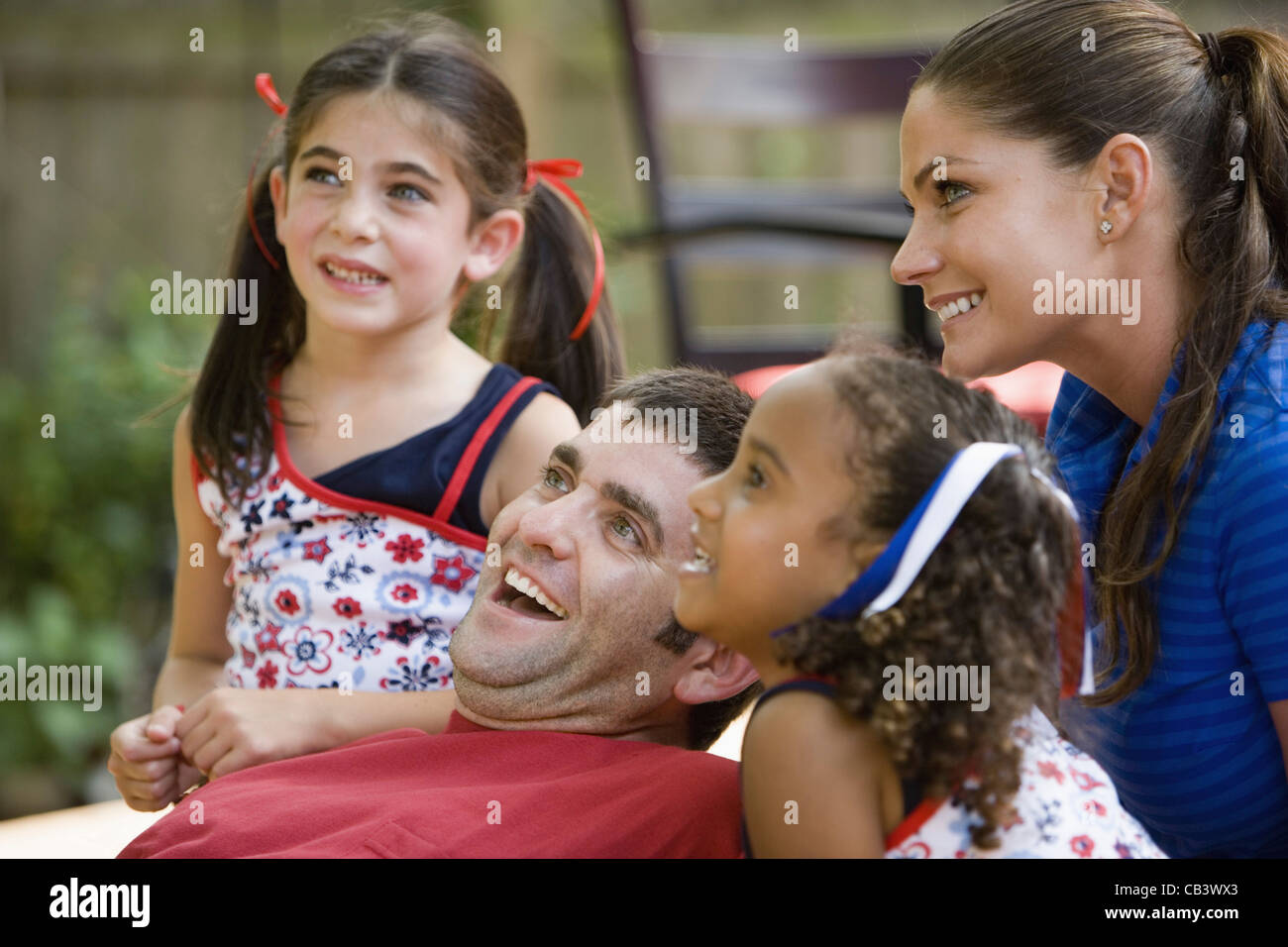 Young family with two girls on backyard patio looking away Stock Photo ...