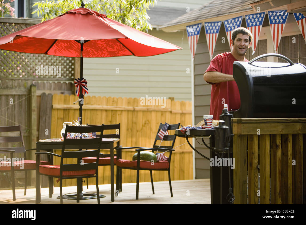 Man cooking on outdoor grill on backyard patio on 4th of July Stock ...