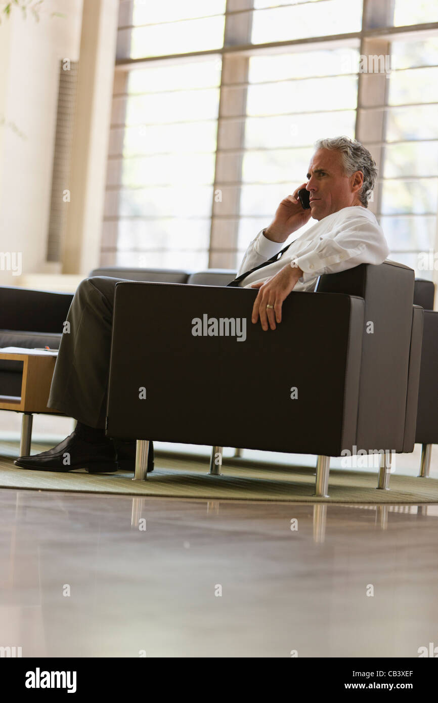 Businessman waiting in office lobby Stock Photo - Alamy