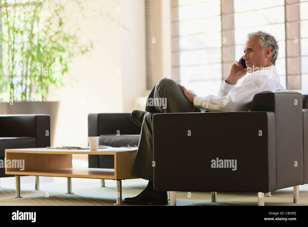 Businessman waiting in office lobby Stock Photo - Alamy