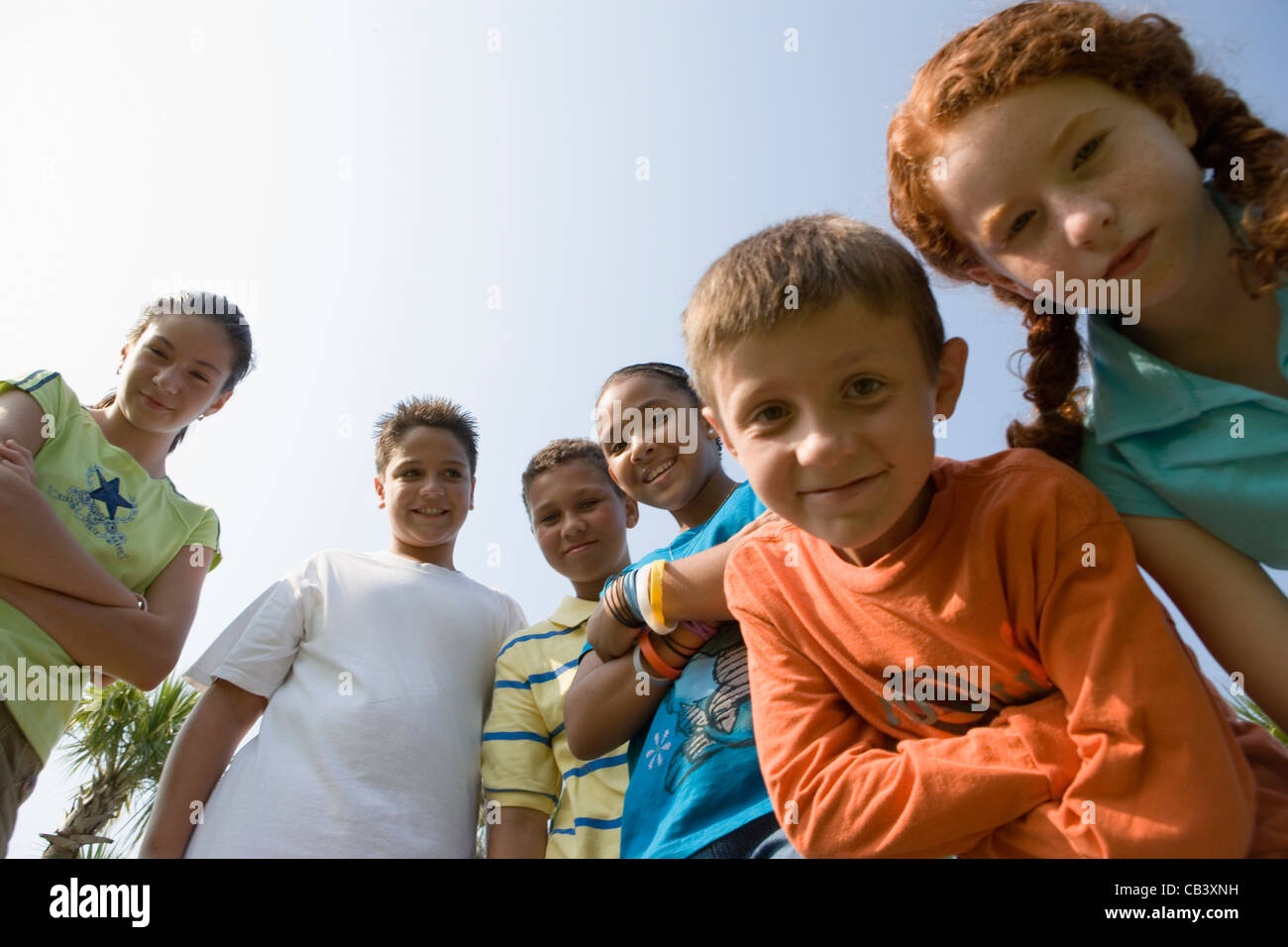 Low angle view of children with folded arms standing together at a ...