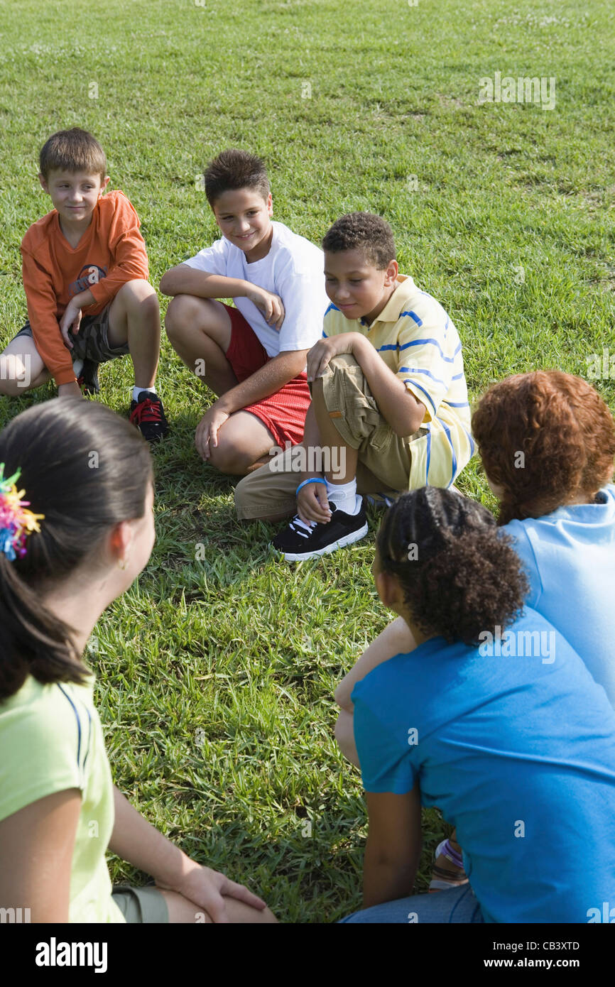 Group of children kneeling on the grass Stock Photo - Alamy