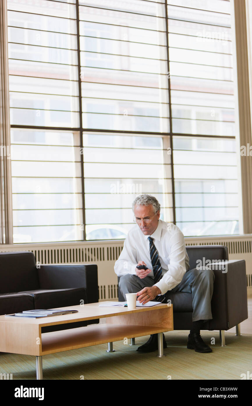 Business executive waiting in office lobby Stock Photo - Alamy