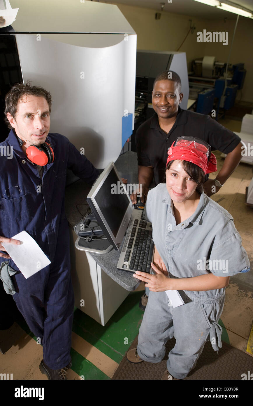 Workers being trained to use a piece of machinery with computer ...