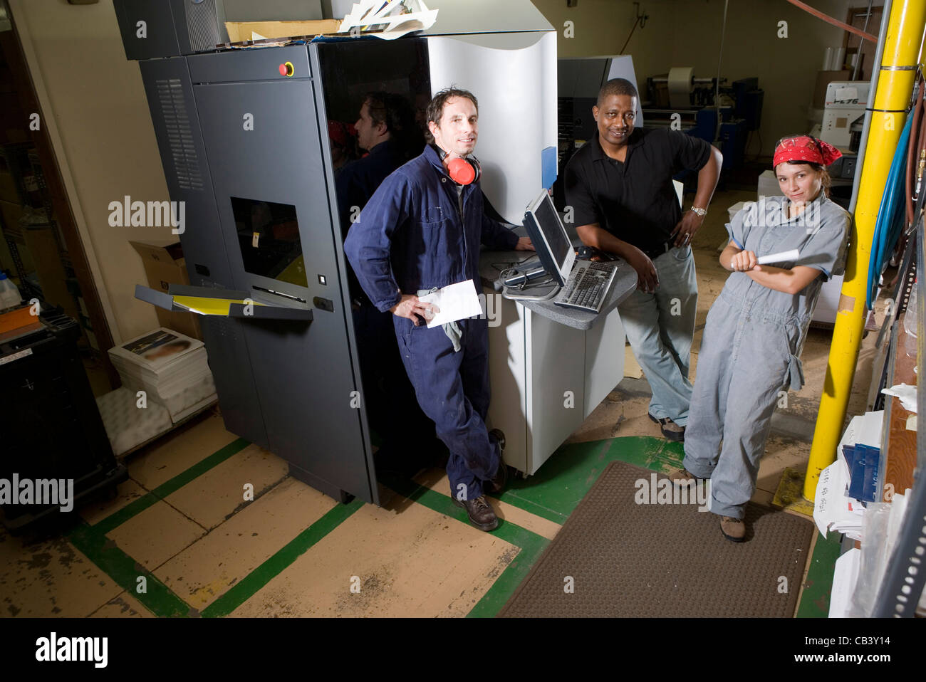 Workers being trained to use a piece of machinery with computer ...