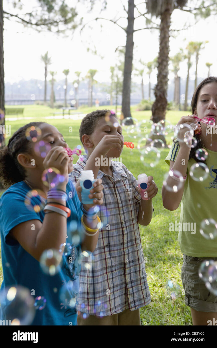 Children blowing bubbles at a park Stock Photo - Alamy
