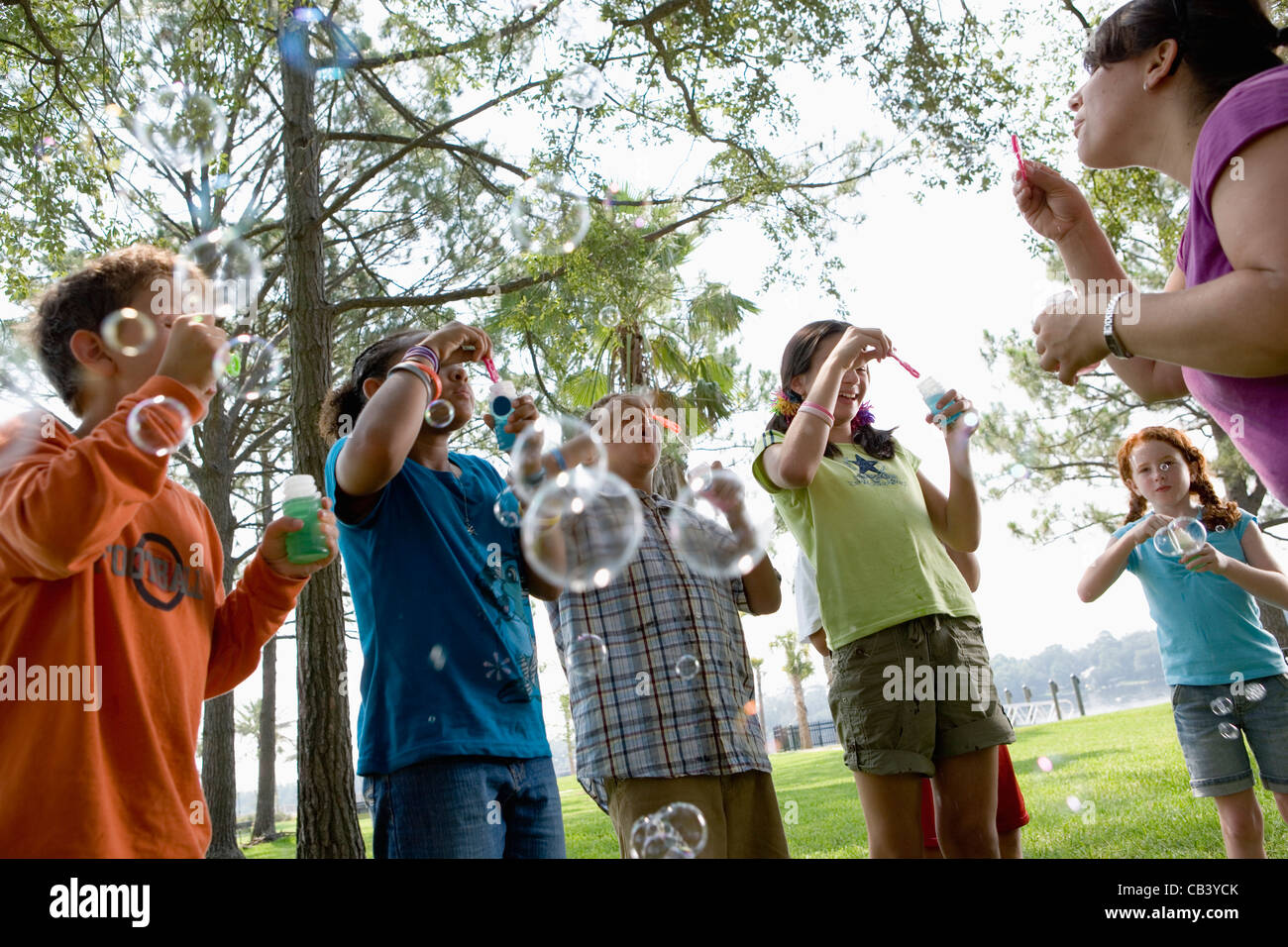 Children and their teacher blowing bubbles at a park Stock Photo - Alamy