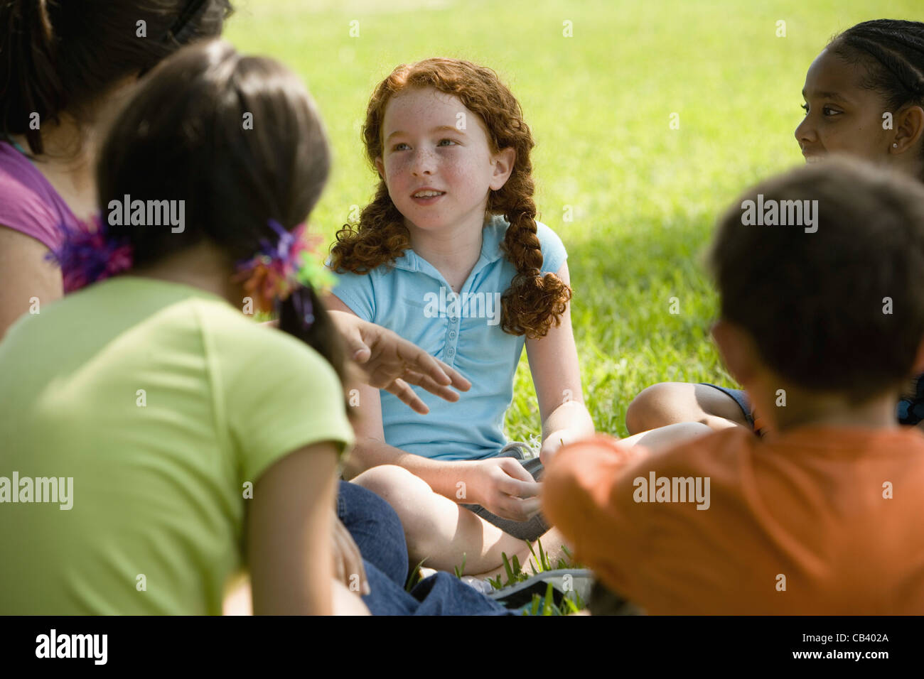 Girl in group listening to teacher Stock Photo - Alamy