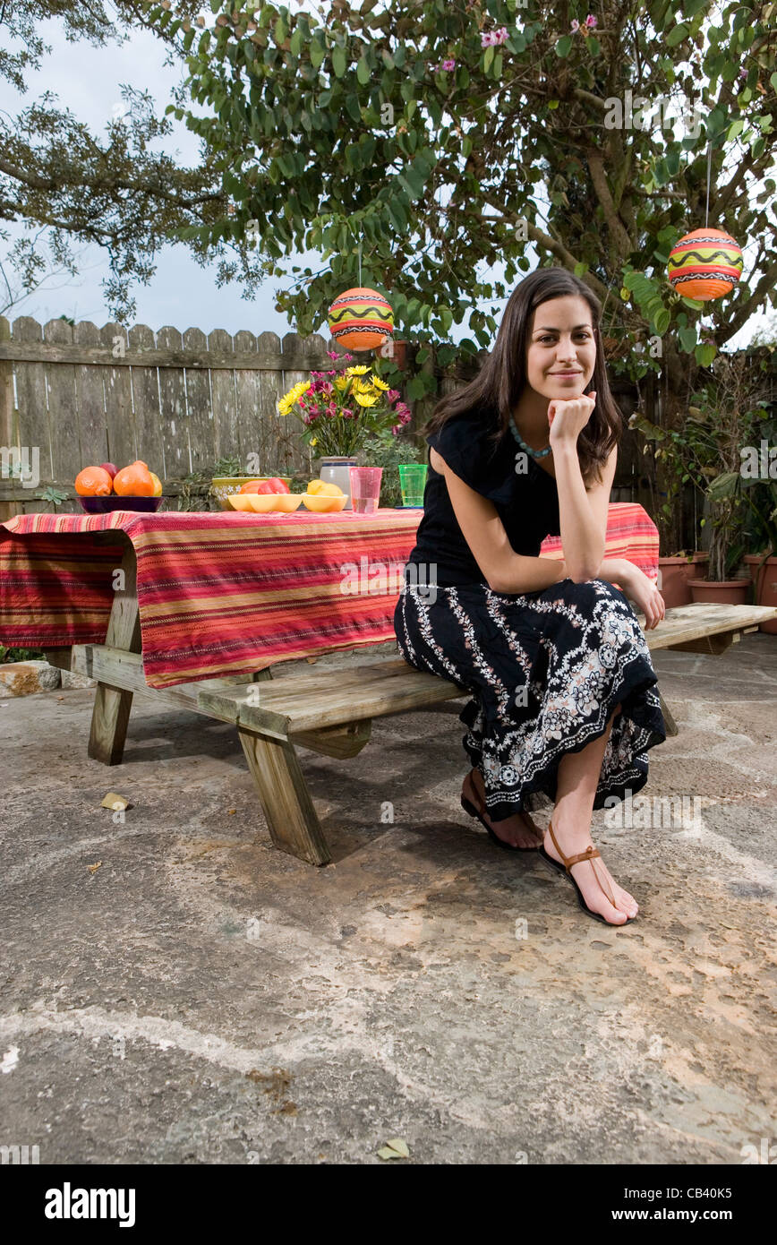 Portrait of a young woman sitting in front of a picnic table Stock ...