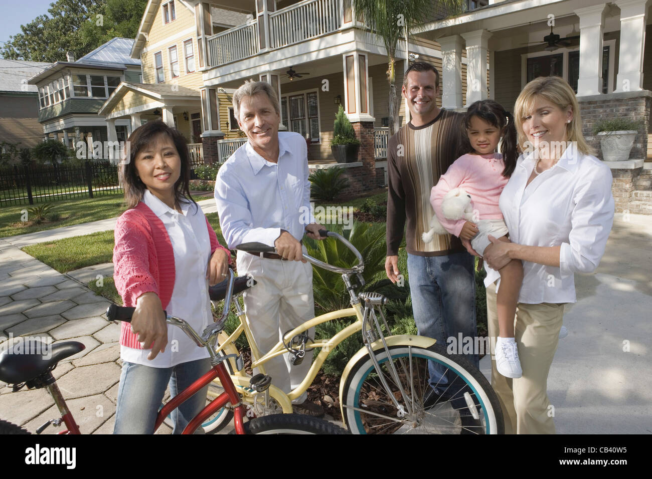 Family with young child standing with neighbors in front of house Stock ...