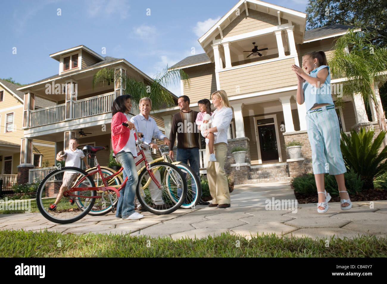 Family with young children conversing with neighbors in front of house ...
