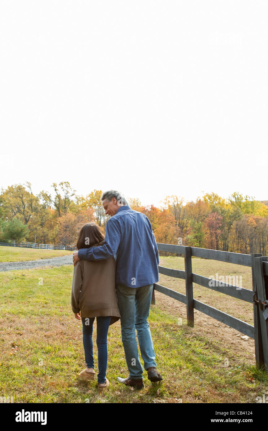 Rear view of father and daughter walking on field Stock Photo - Alamy