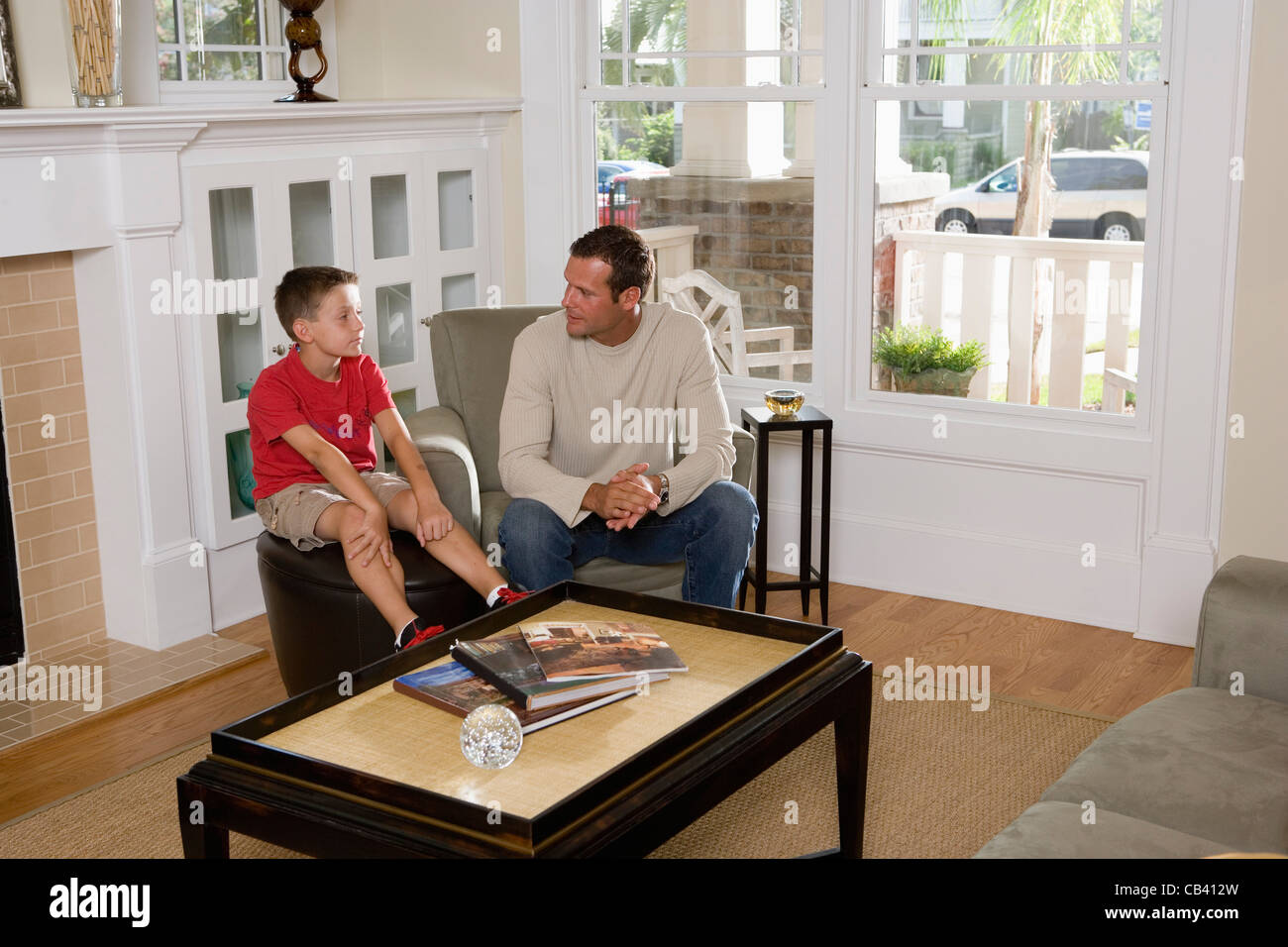 Father and son sitting in a living room Stock Photo - Alamy