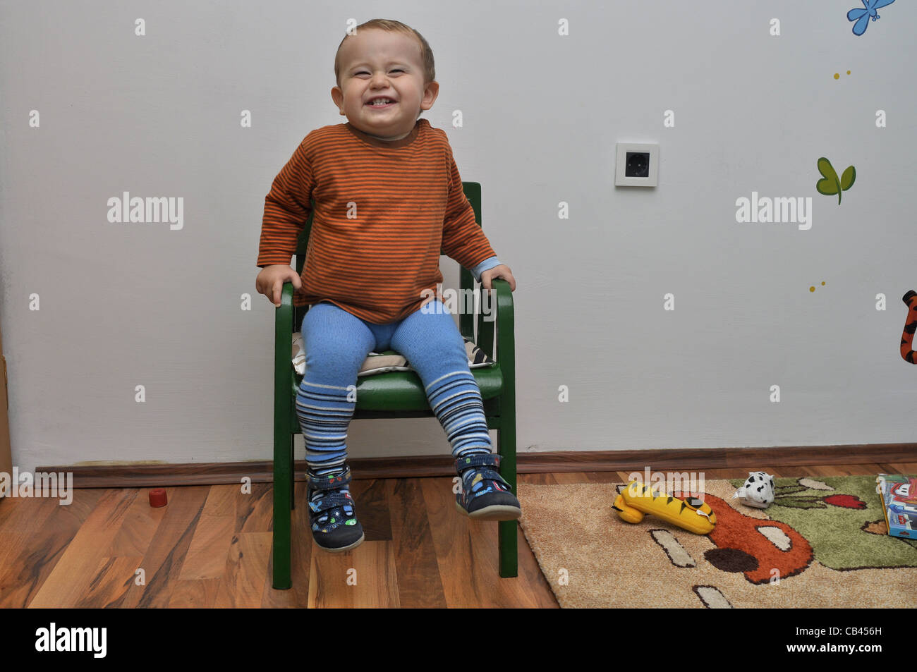 Boy sitting in chair in child room Stock Photo - Alamy