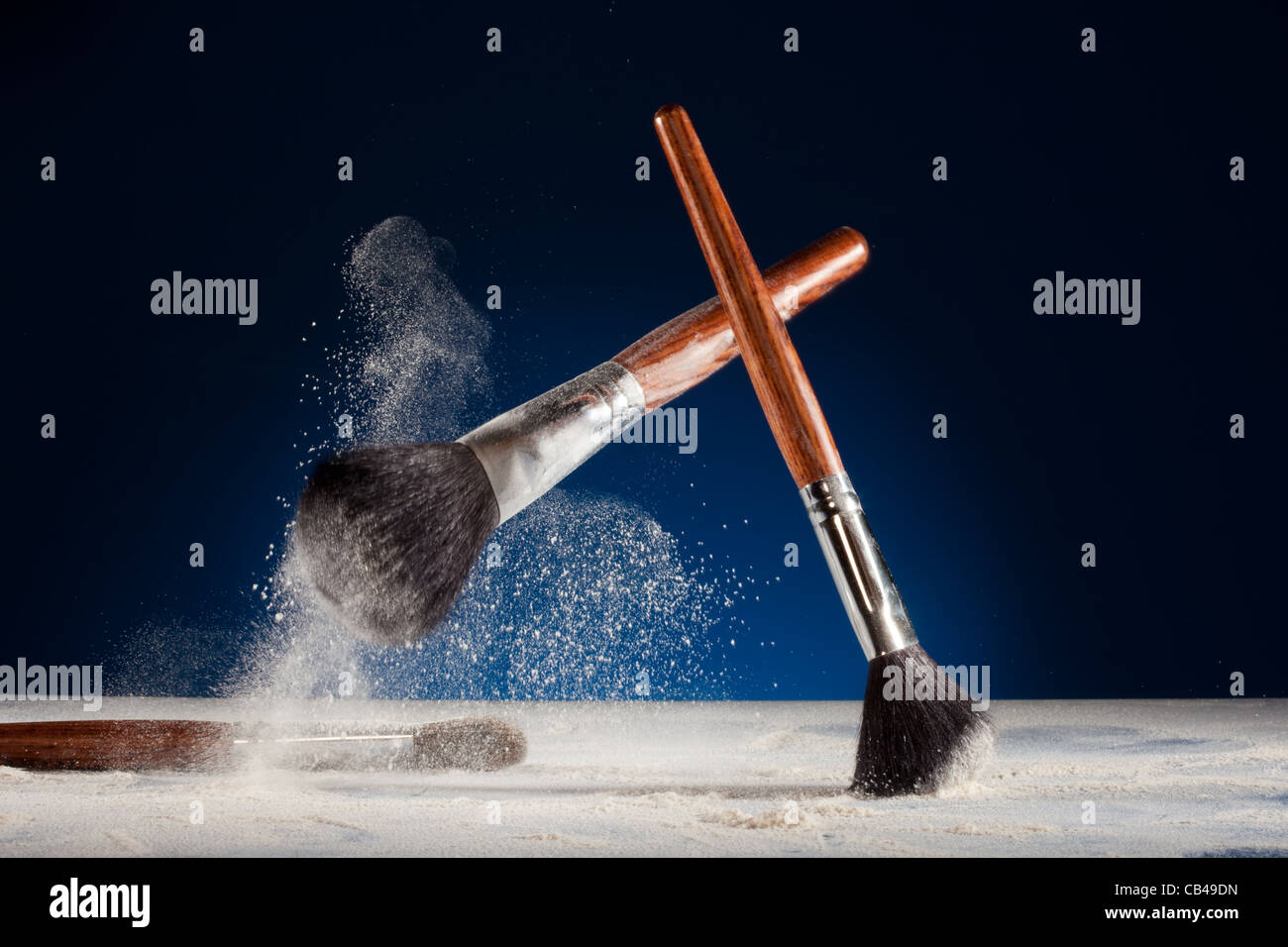 Creative shoot of makeup brushes falling in motion with powder flying ...