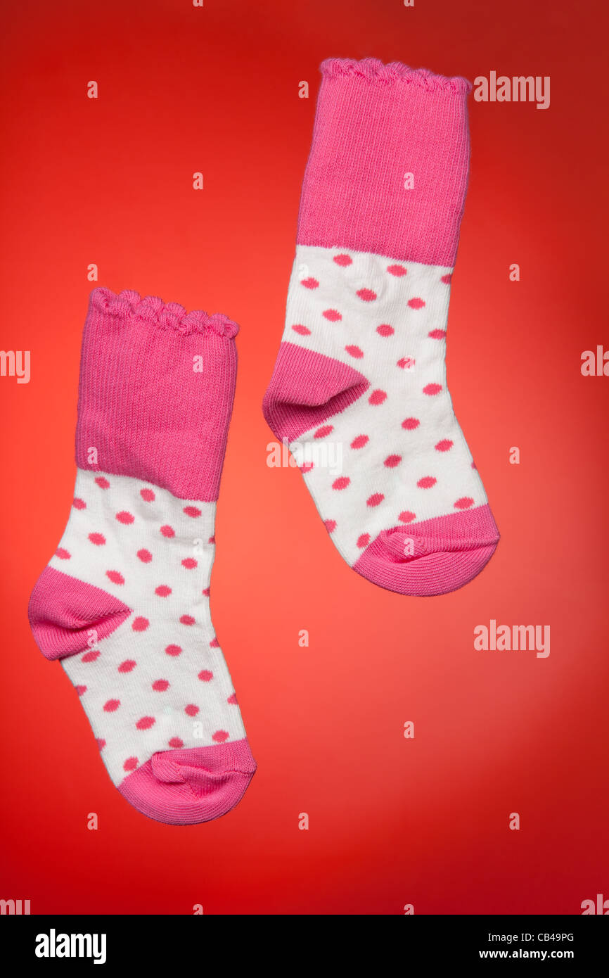 Nice small kids socks on red background Stock Photo - Alamy