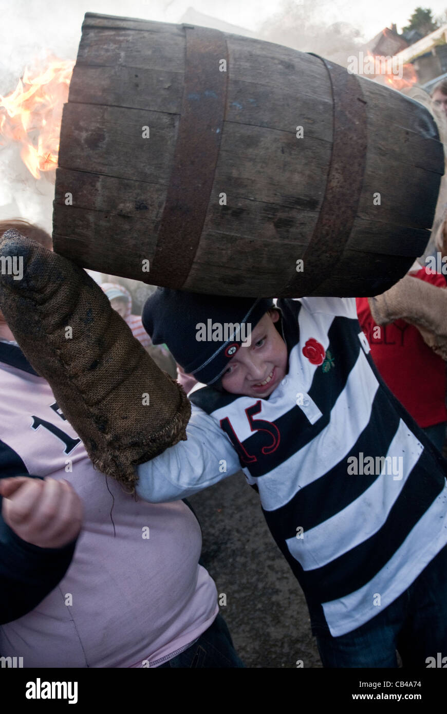 A young barrel roller runs through the crowd with a burning barrel at ...