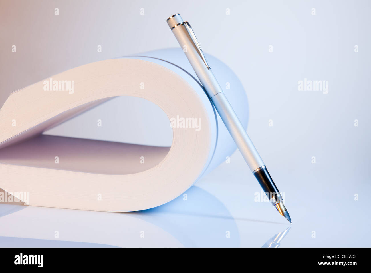 Rolled paper with fountain pen on reflective table Stock Photo - Alamy