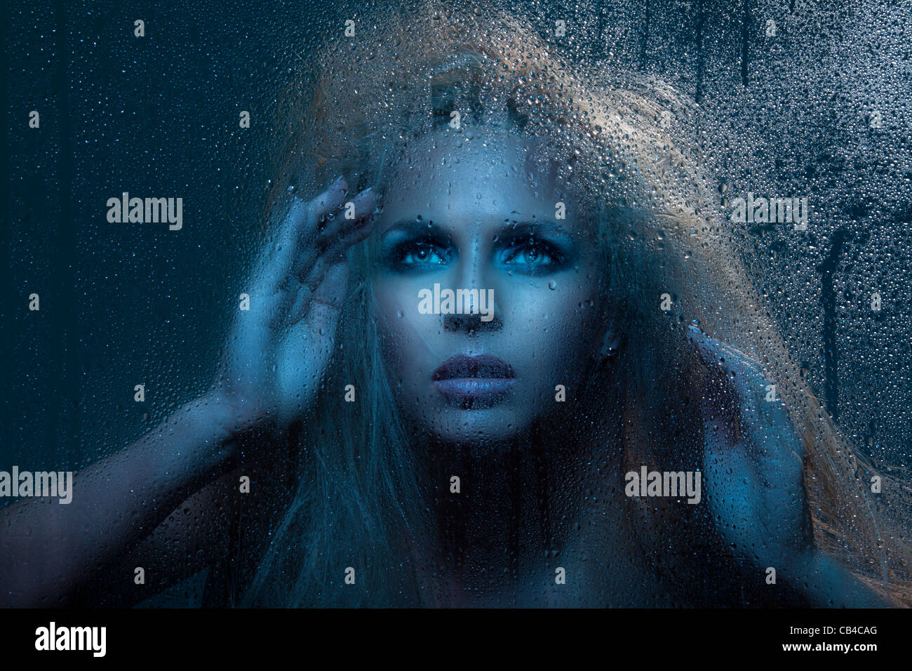 Beautiful woman looking through night window with rain outside Stock ...