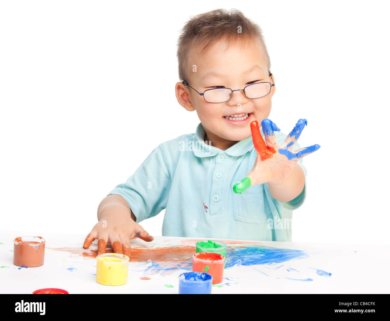 Chinese boy painting with hands with different color paint on his palms ...