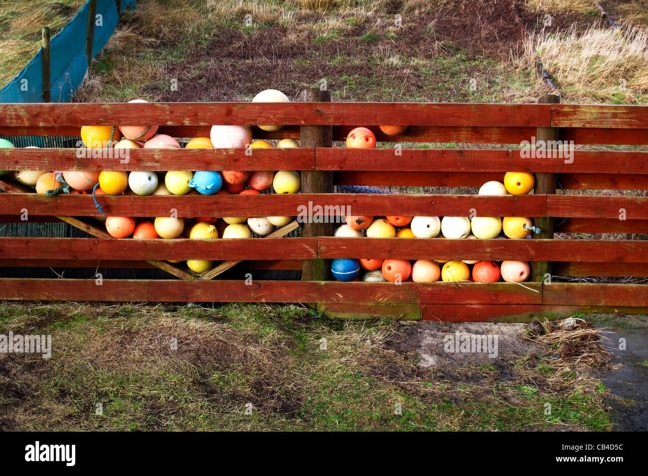 Colourful fishing net floats behind fence Stock Photo - Alamy